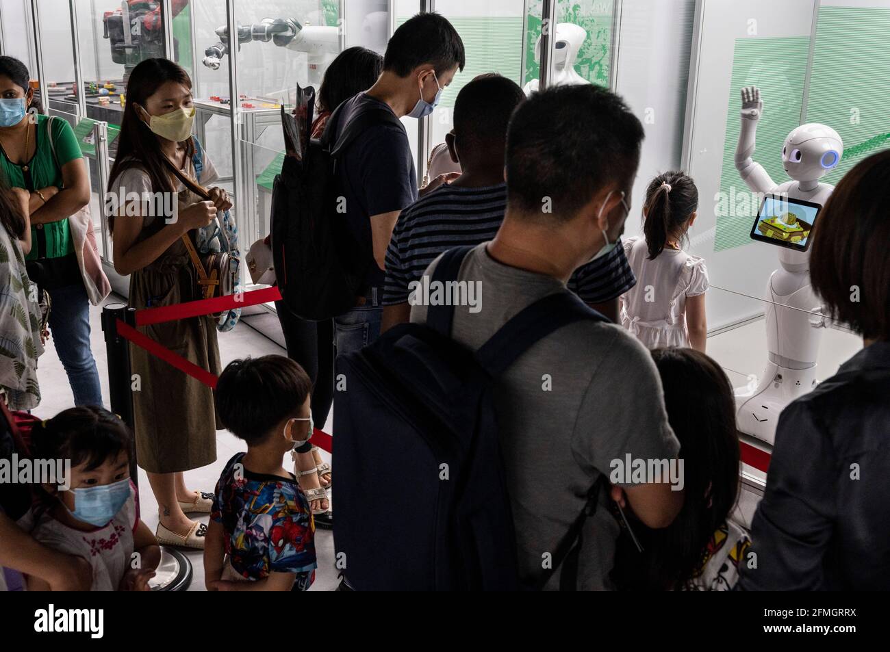 Visitors interact with a robot during the 'ROBOTS' exhibition at the ...