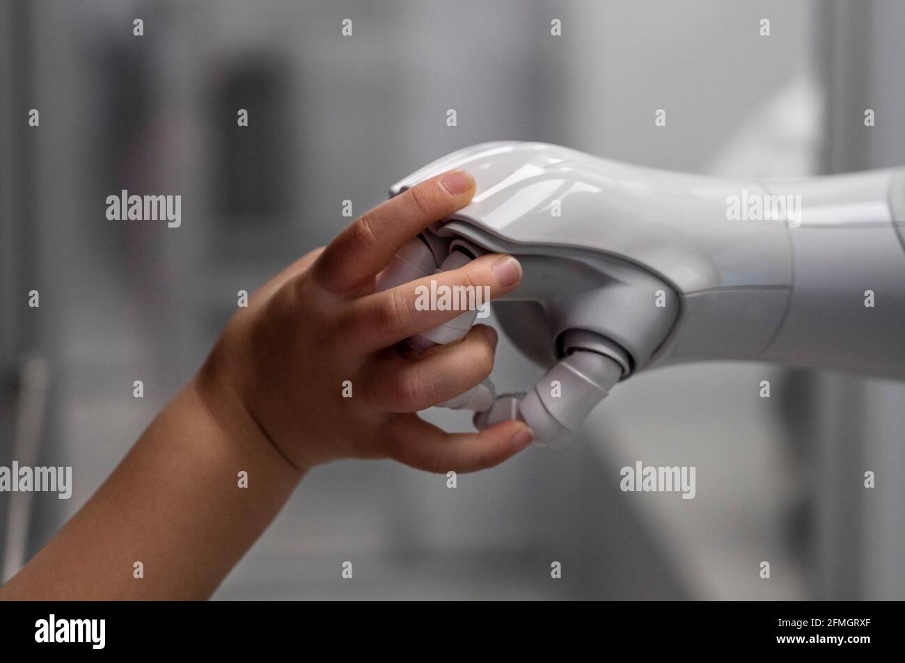A young visitor interacts with a robot during the 'ROBOTS' exhibition ...