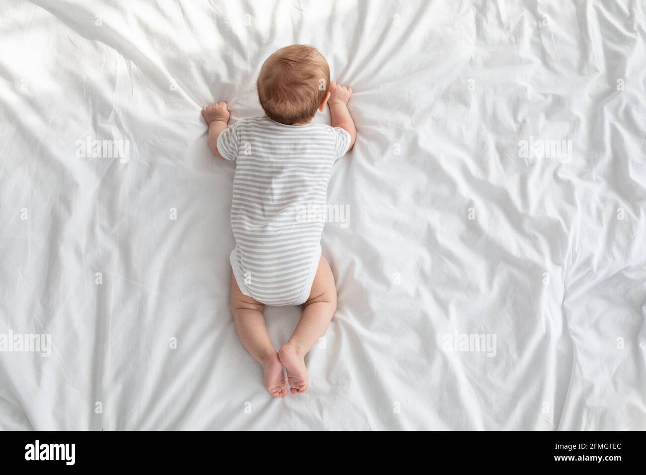 Baby Development Concept. Top View Of Infant Child Crawling On Bed ...