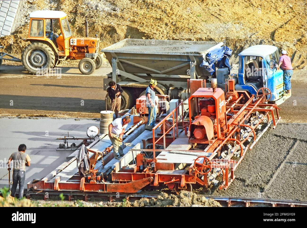 Archival 1986 aerial view of contractor workers on concrete road laying ...