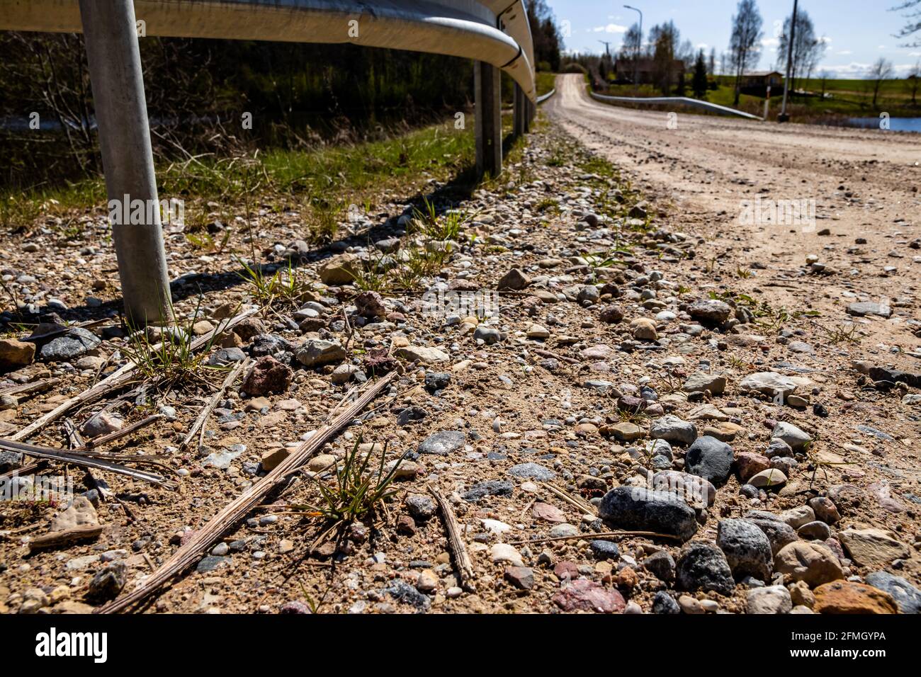 A closeup of a dirt road with small pebble stones through the ...