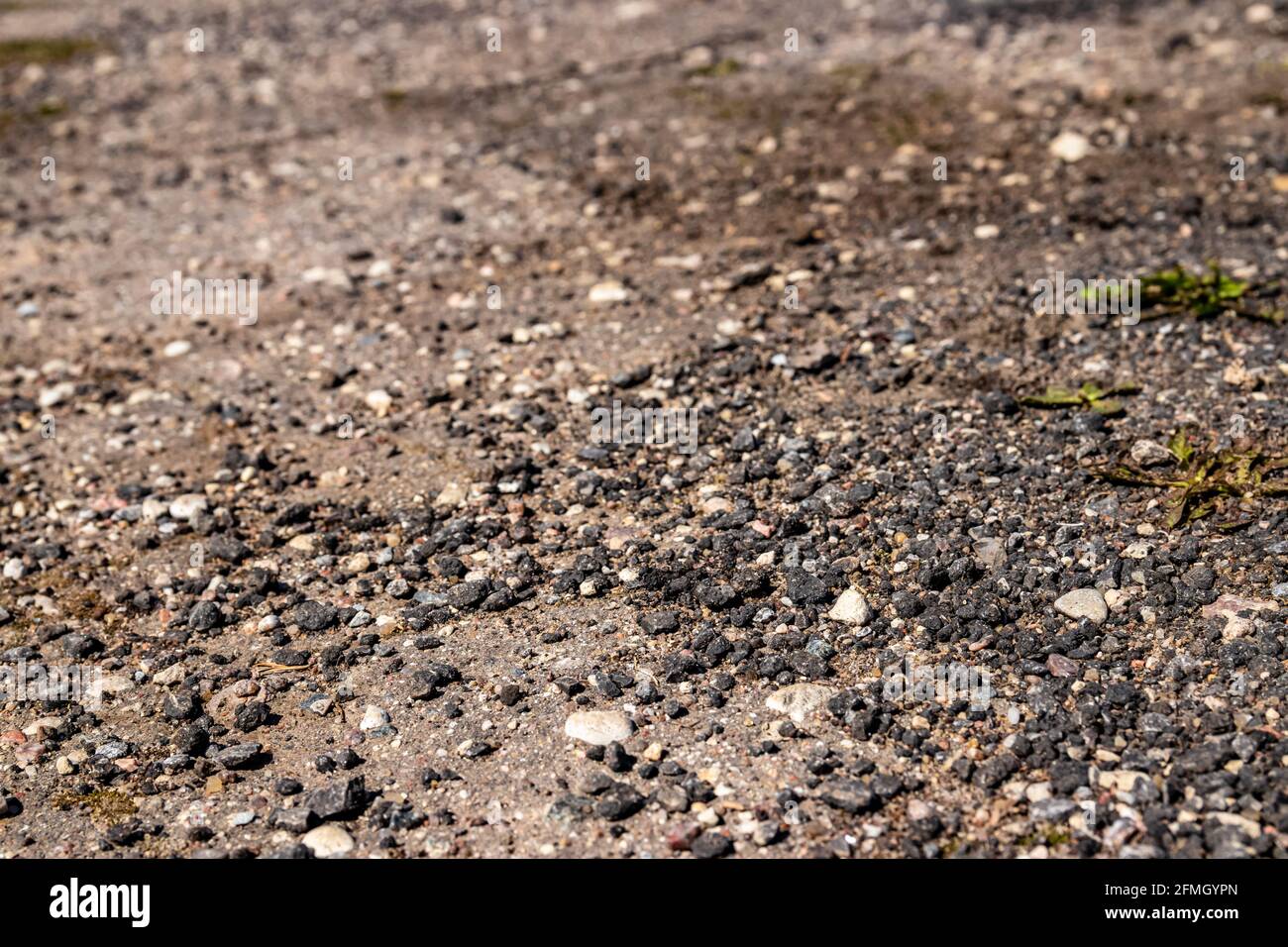 A closeup surface texture with small pebble stones on a dirty ground ...
