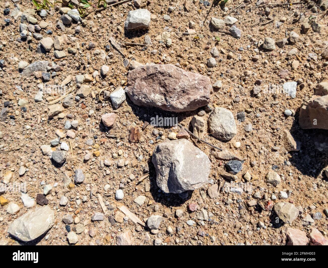 A closeup surface texture with small pebble stones on a dirty ground ...
