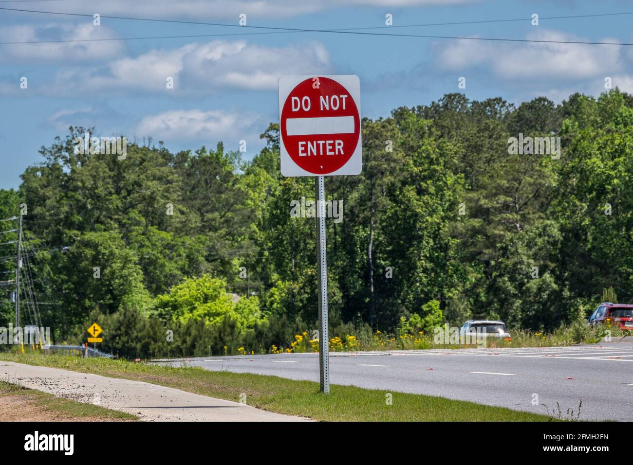 A four lane highway with a Do Not Enter sign on a post alongside the ...