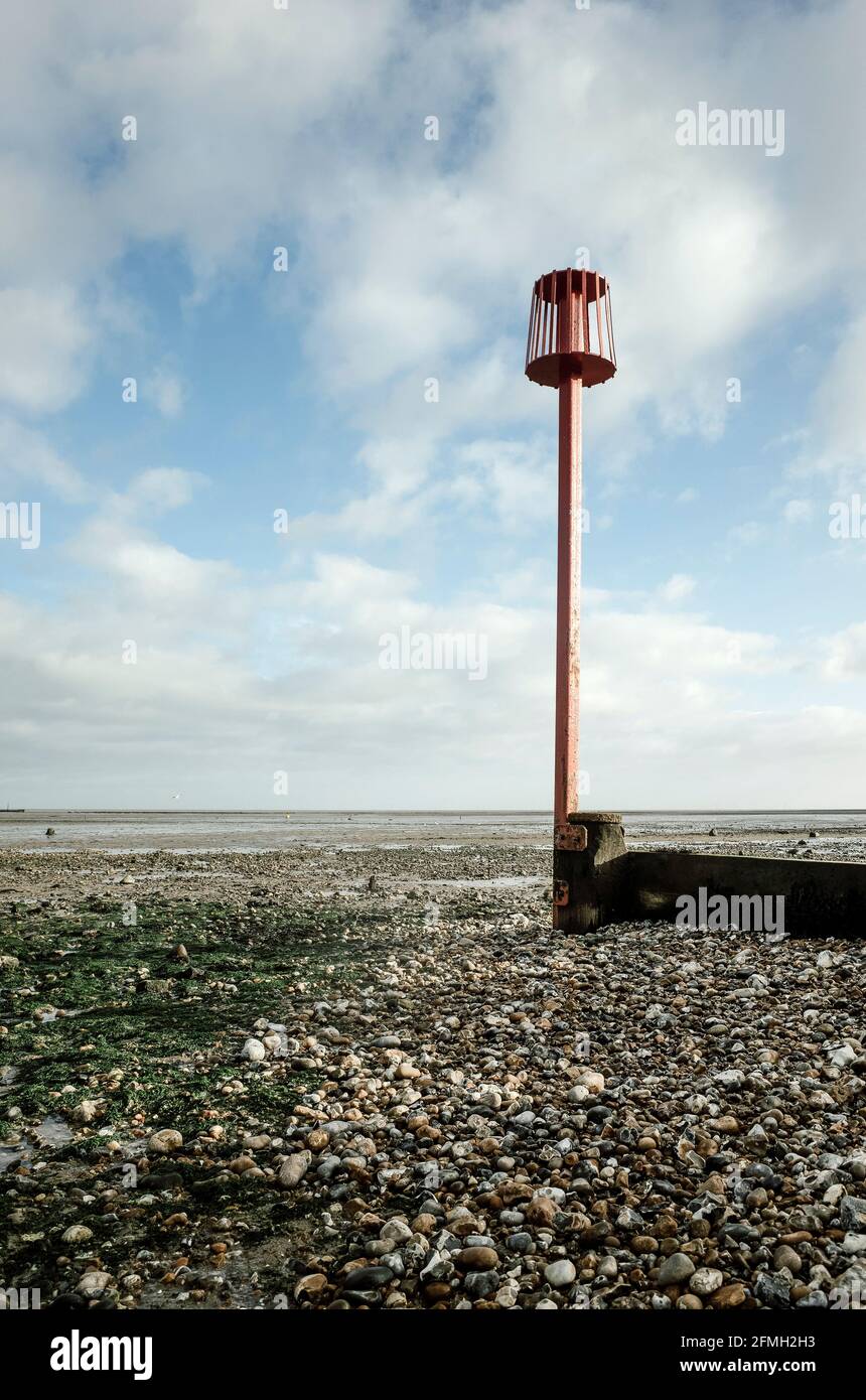 A red painted port lateral mark or channel marker on the shingle beach ...