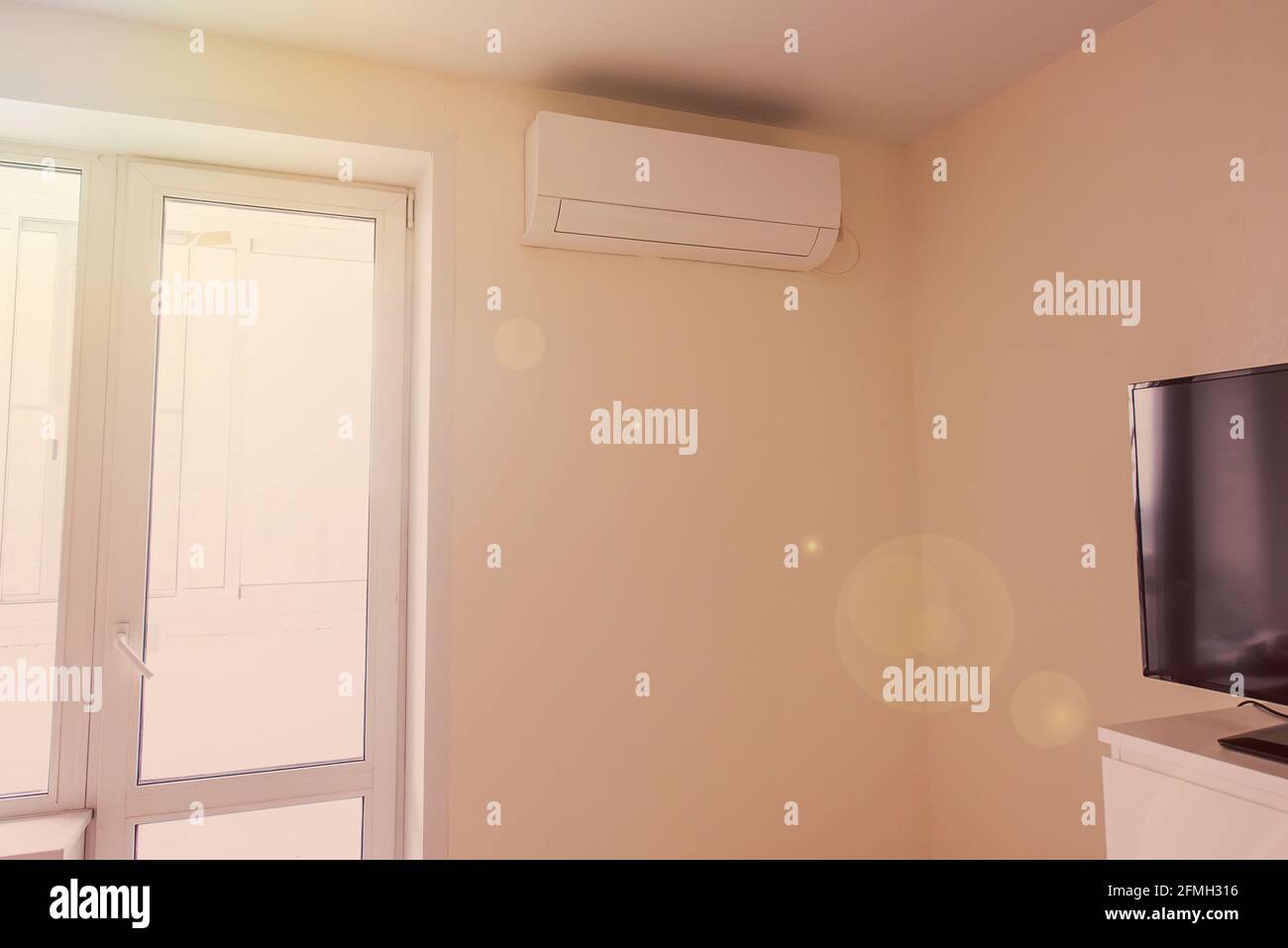 The air conditioner is installed in the corner of the real room next to ...