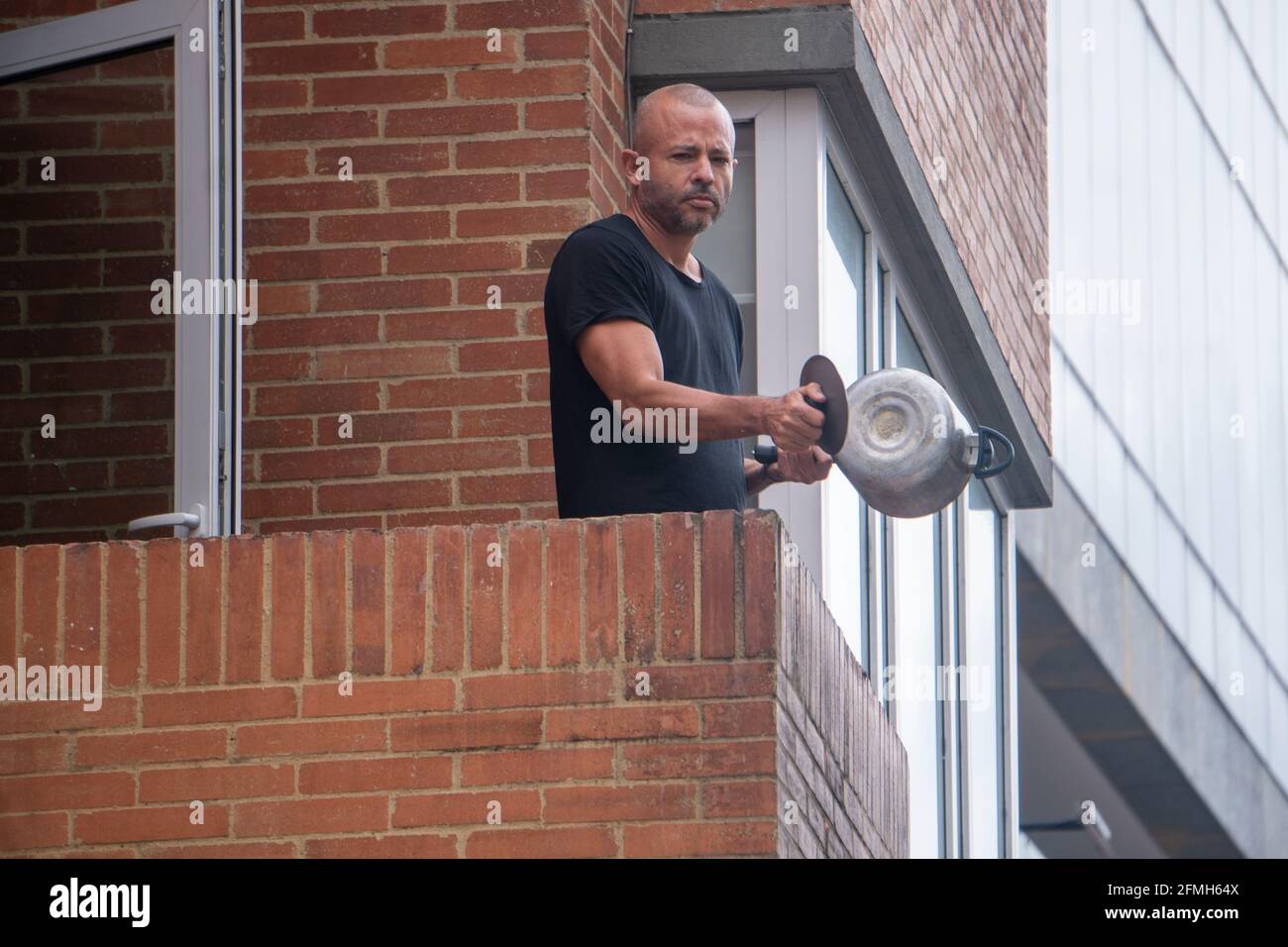 A person hits the pot with a lid supporting the May Day march Stock ...
