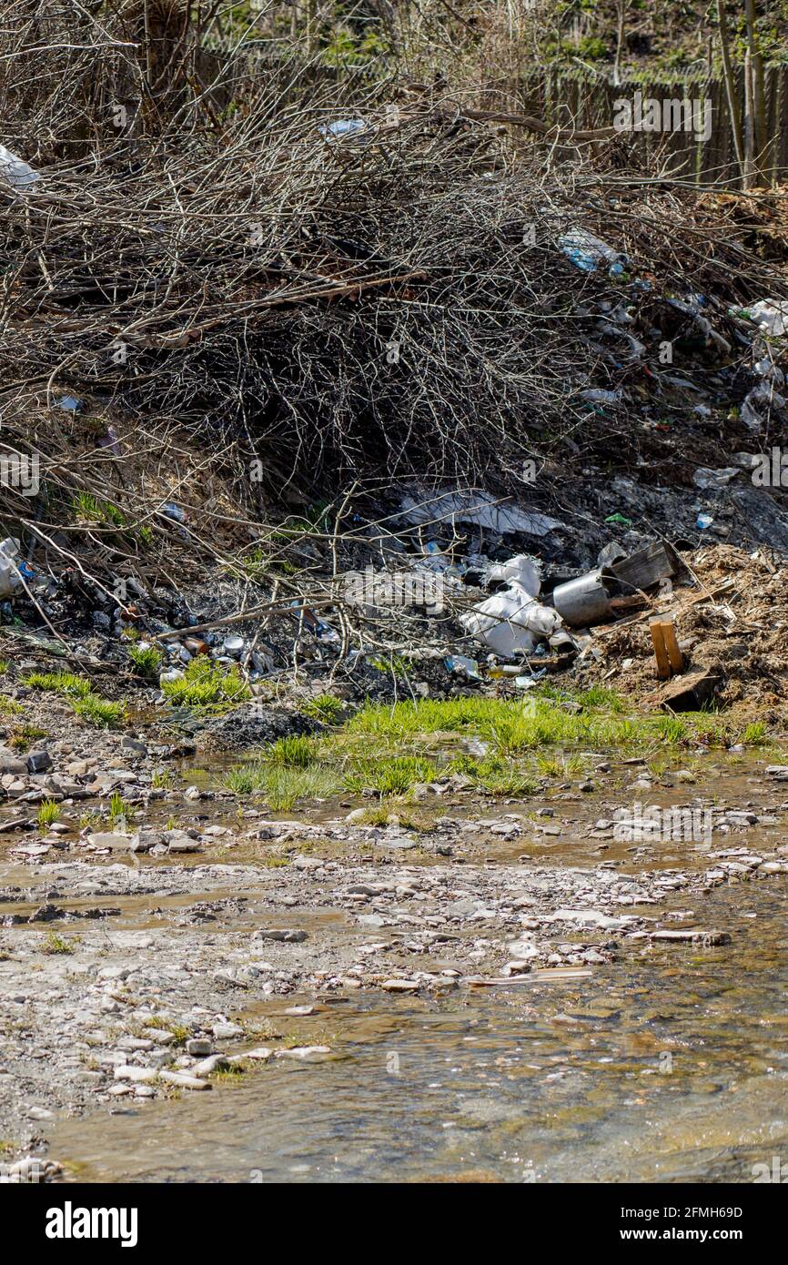 A beautiful small stream is littered with a bunch of garbage, empty ...