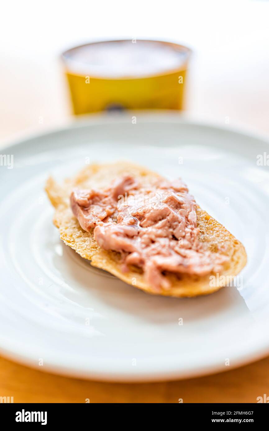 Canned cod liver in oil spread fish on toast bread plate on table with ...