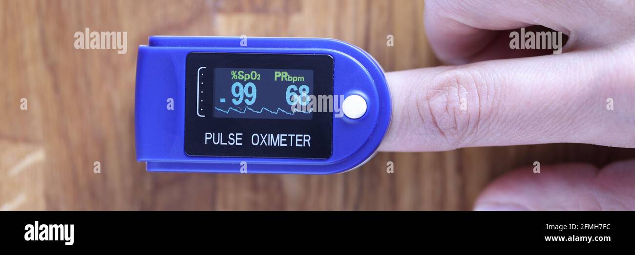 Pulse oximeter is put on finger of womans hand Stock Photo - Alamy
