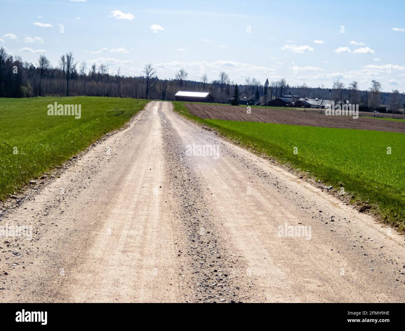 An empty dirt road through the countryside and grass field Stock Photo ...