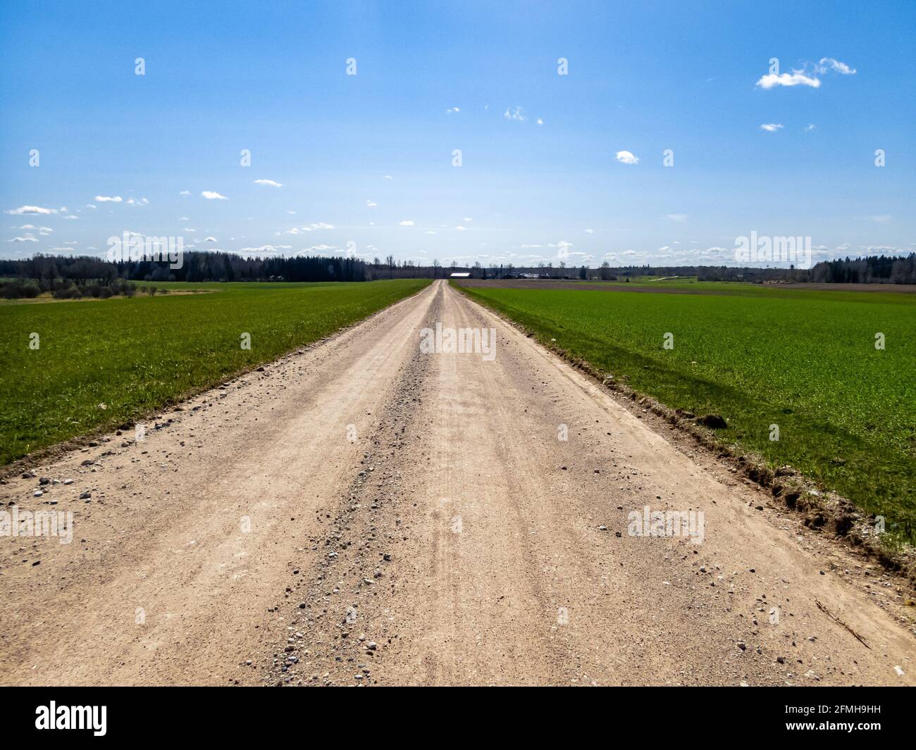 An empty dirt road through the countryside and grass field Stock Photo ...