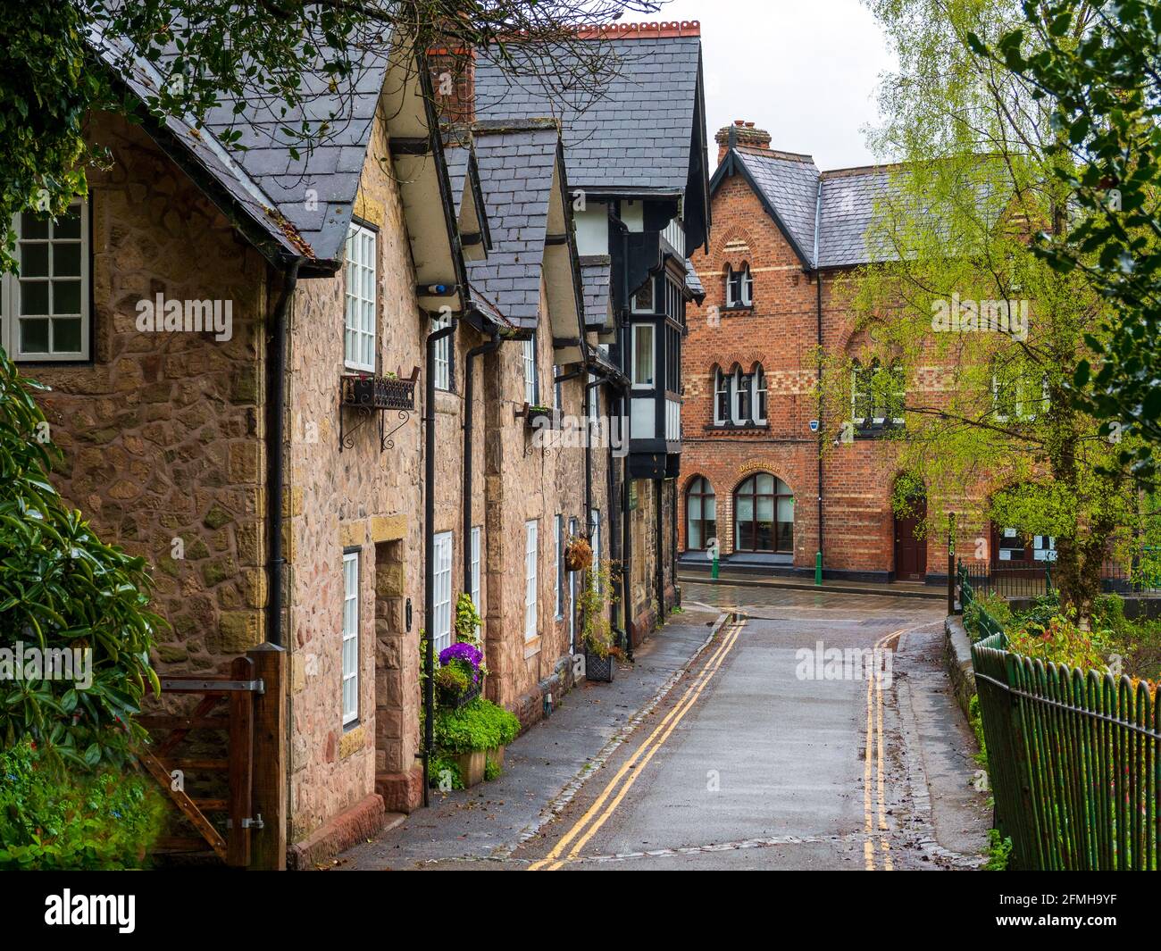 English village houses and street in the spring on a wet grey sky day ...