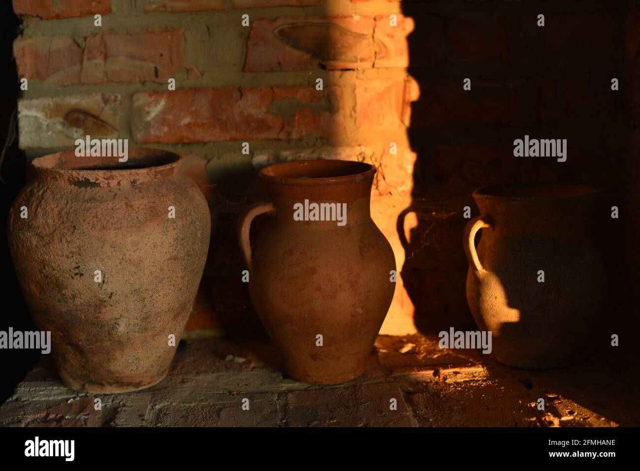 Old barbecue oven, with ancient clay pots and stone millstones. A jug ...