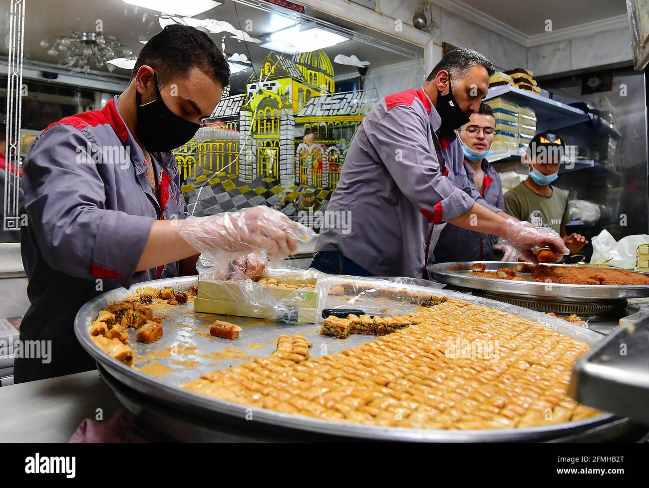 Damascus, Syria. 9th May, 2021. Sweet makers prepare traditional Syrian ...