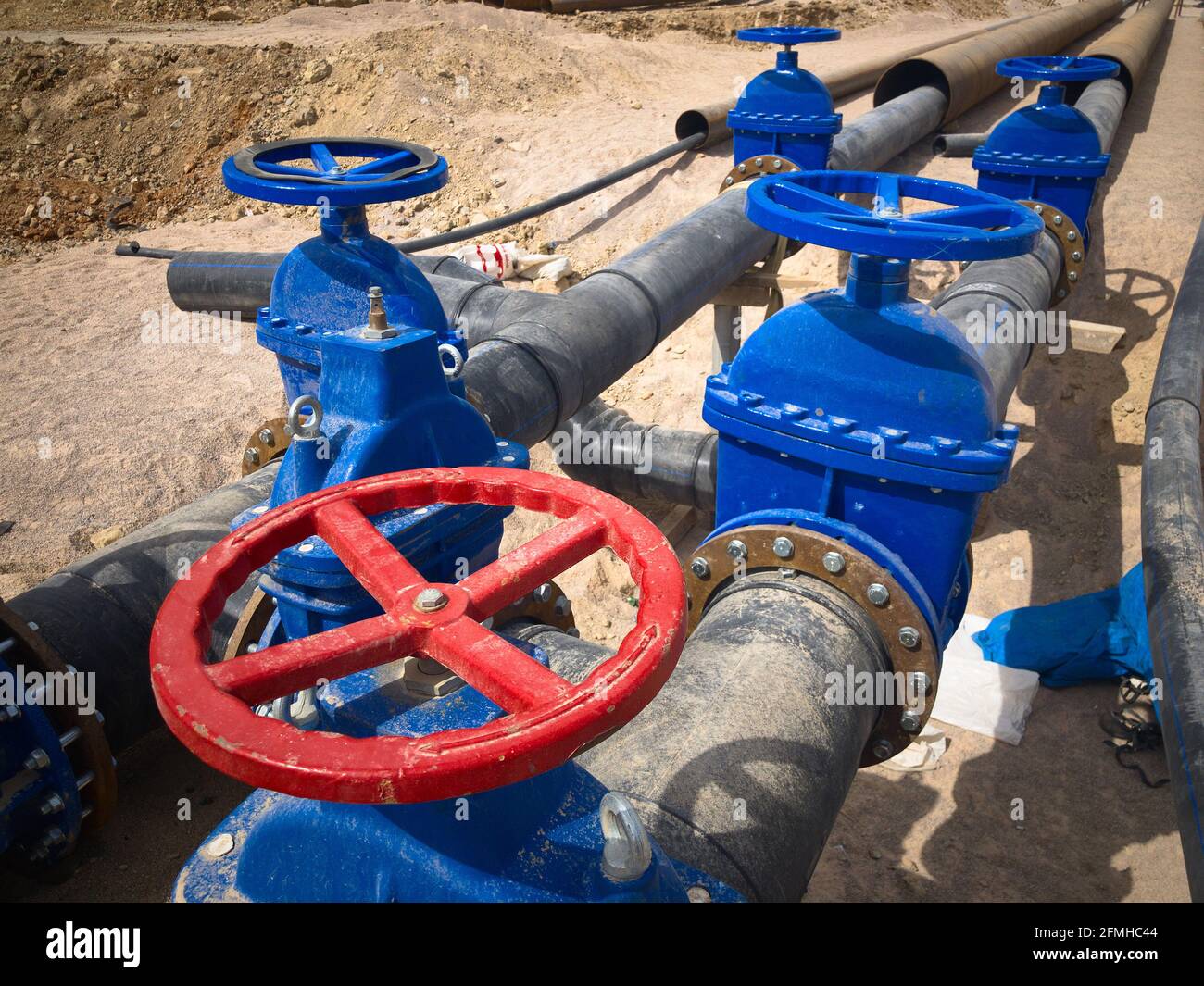 Valves on pipeline in ground. Pipe valves in trench Stock Photo - Alamy