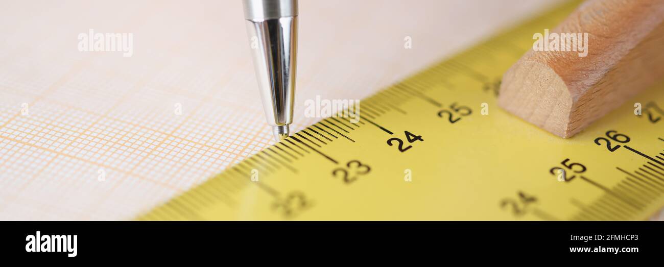 Ballpoint pen drawing line under ruler on graph paper closeup Stock ...