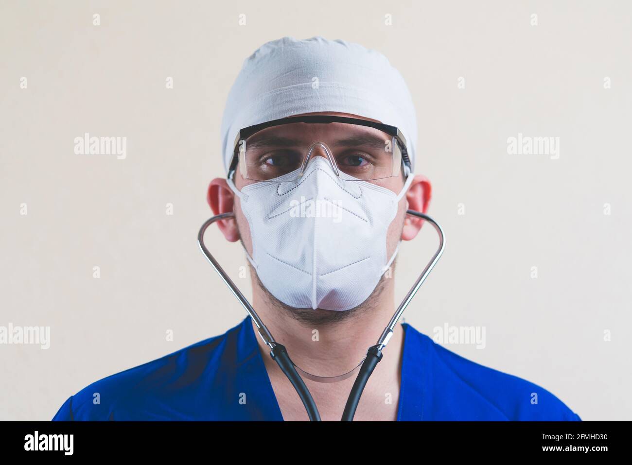 Young doctor portrait in blue surgeon suit and protective breathing ...