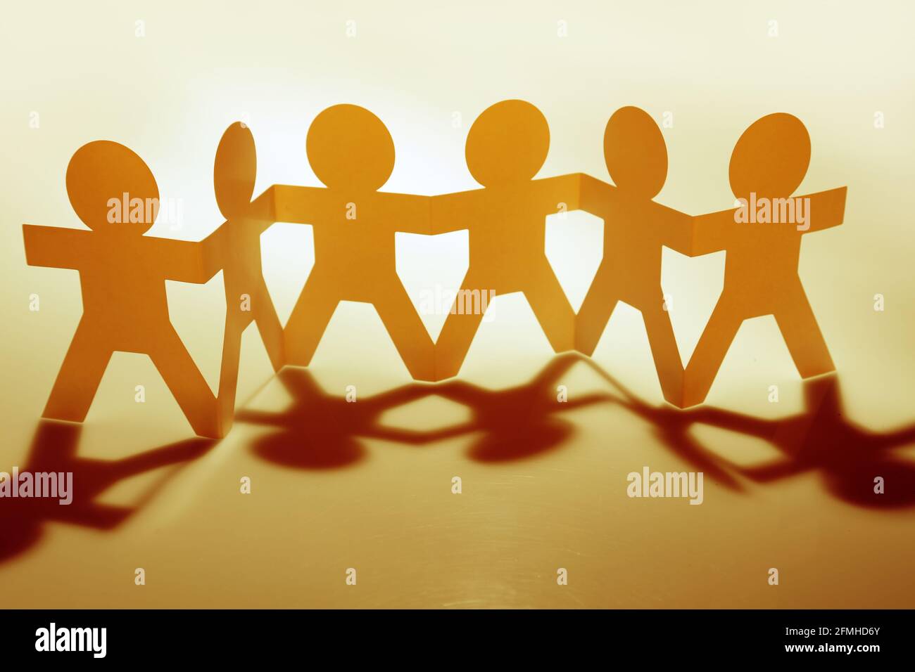 Paper chain team holding hands. Teamwork. Partnership Stock Photo - Alamy