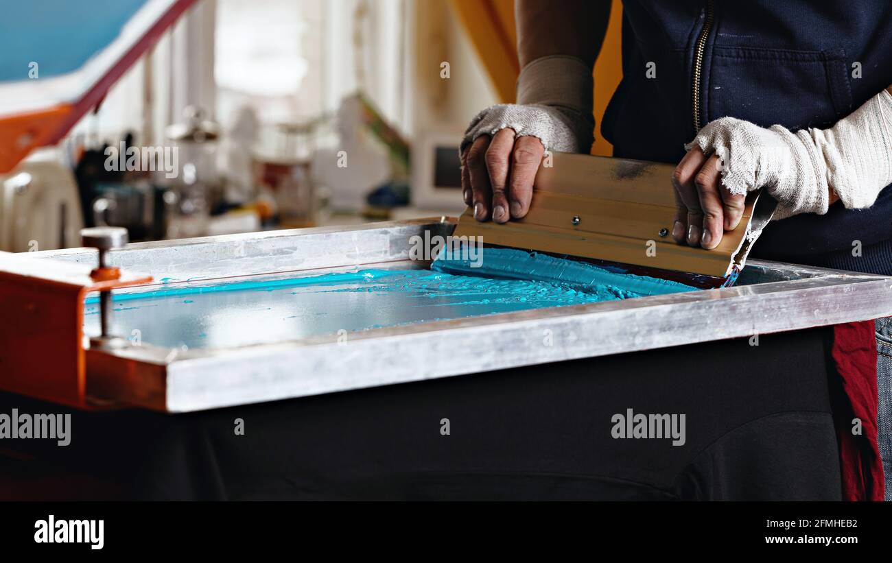 selective focus photo of male hands with squeegee. serigraphy ...