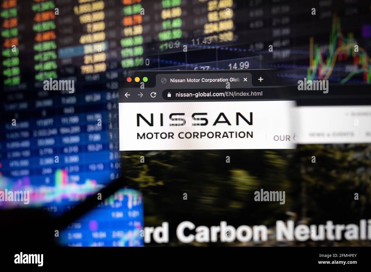 Nissan company logo on a website with blurry stock market developments in the background, seen ...