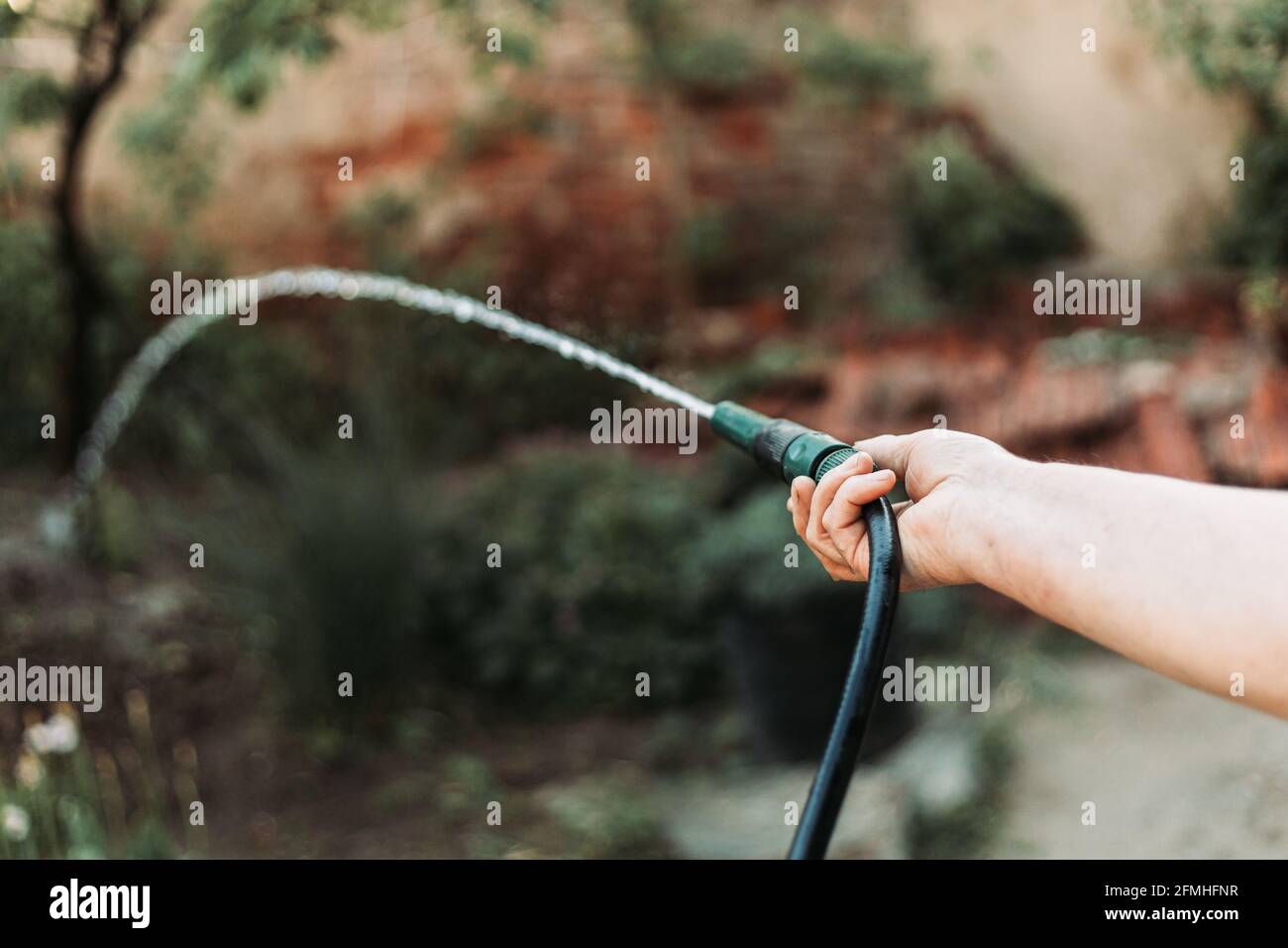 Hand holding the hose hi-res stock photography and images - Alamy