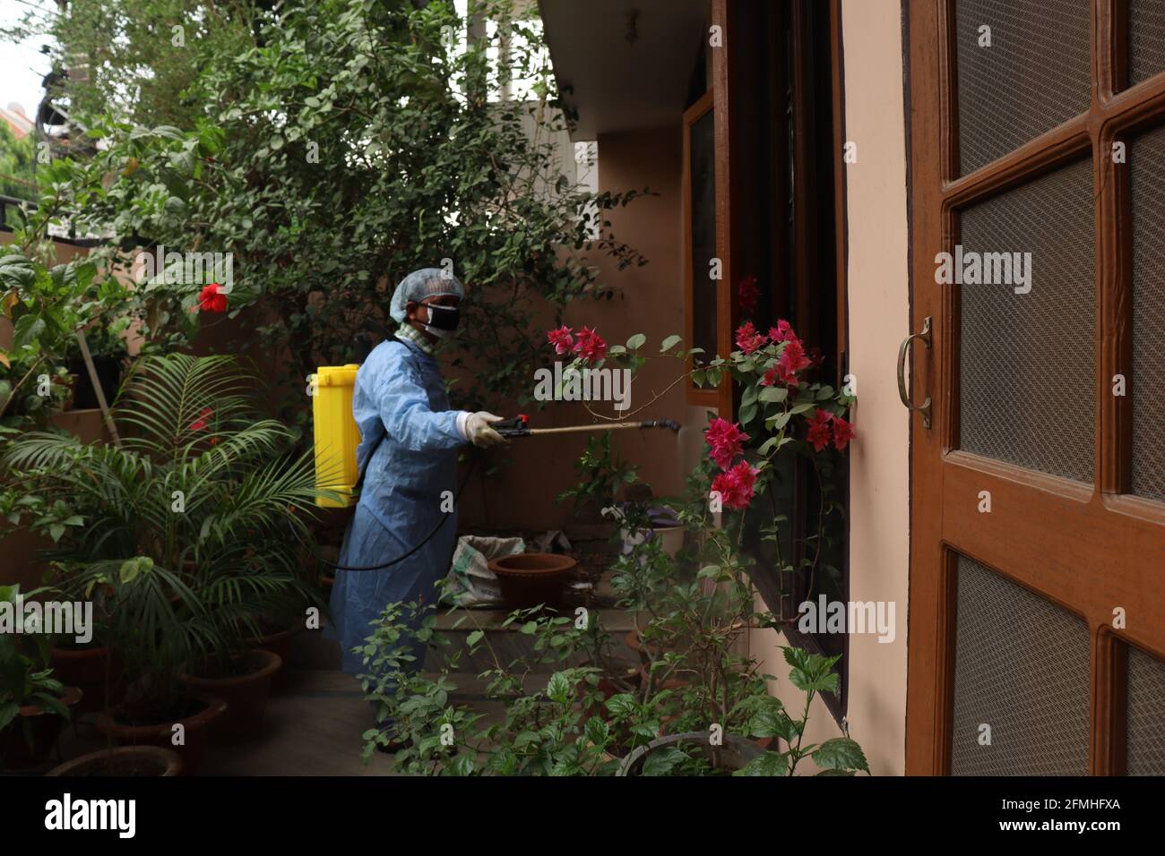 A professional worker in PPE uniform using sanitizing spray Stock Photo ...