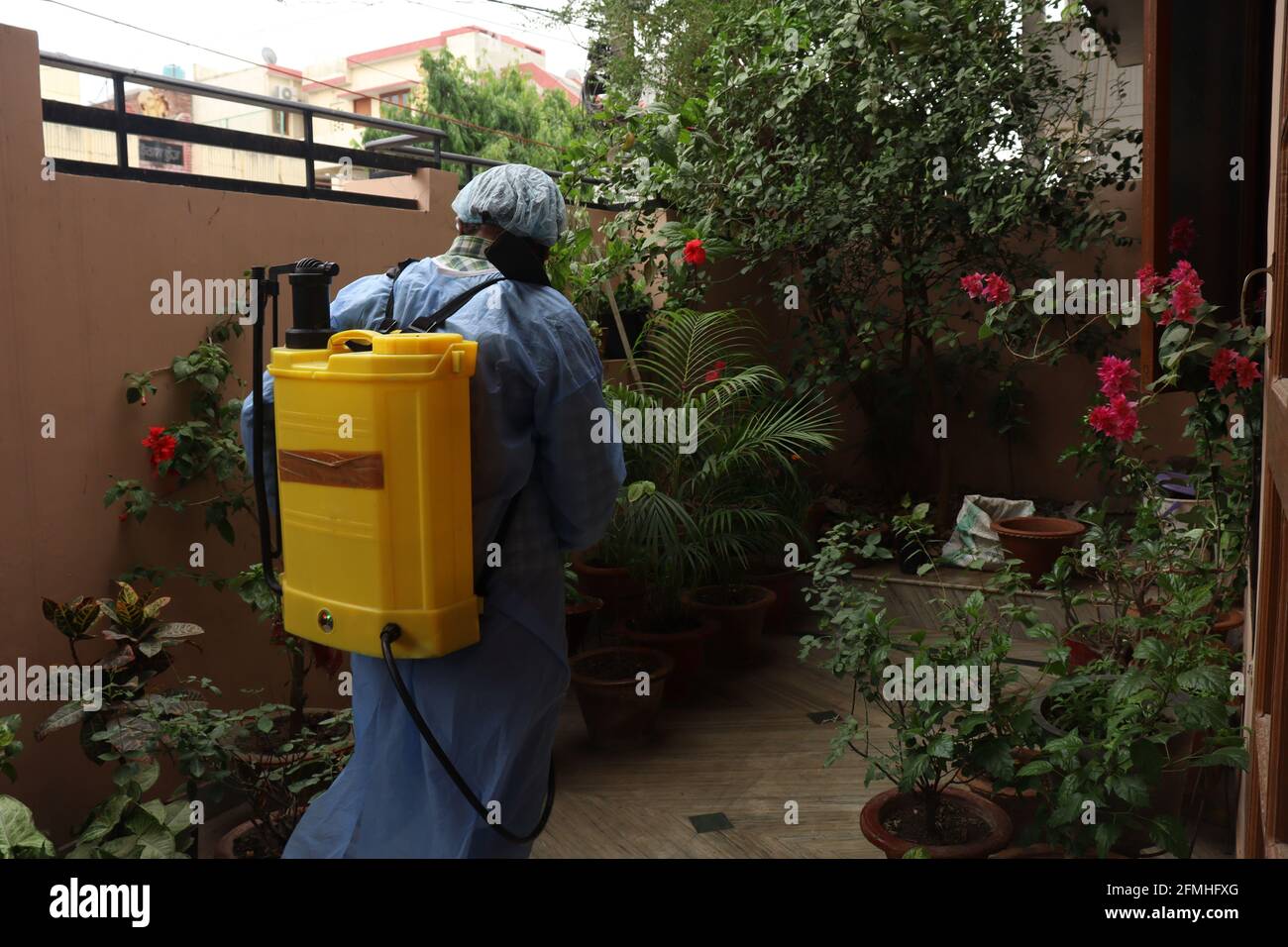 A professional worker in PPE uniform using sanitizing spray Stock Photo ...
