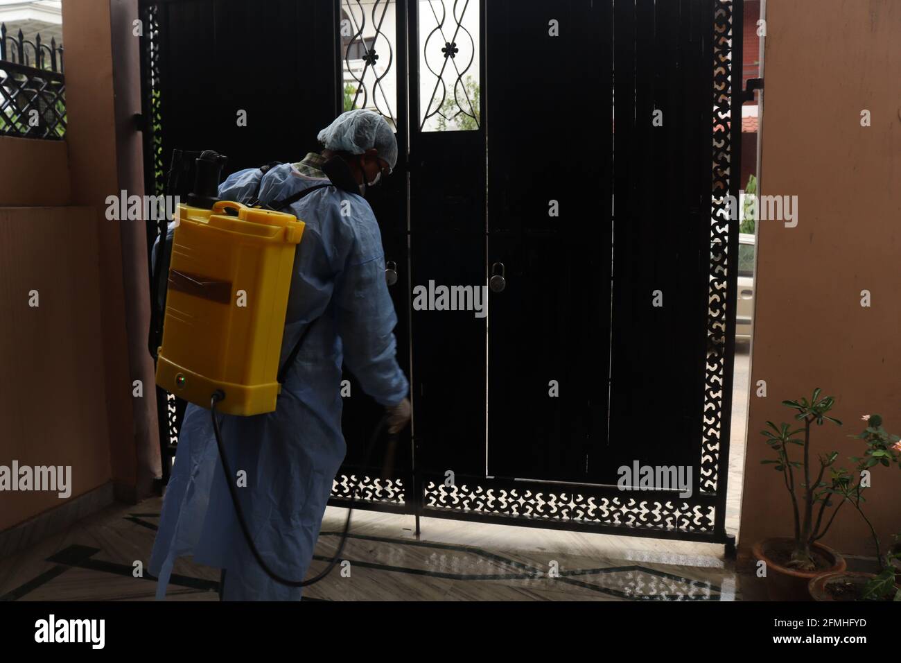 A professional worker in PPE uniform using sanitizing spray Stock Photo ...