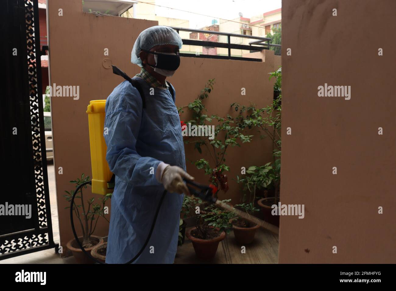 A professional worker in PPE uniform using sanitizing spray Stock Photo ...