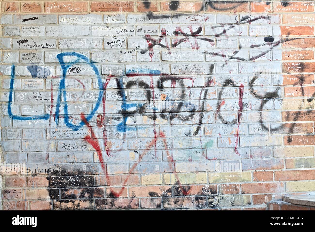 a colorful brick wall with spray can writing Stock Photo - Alamy