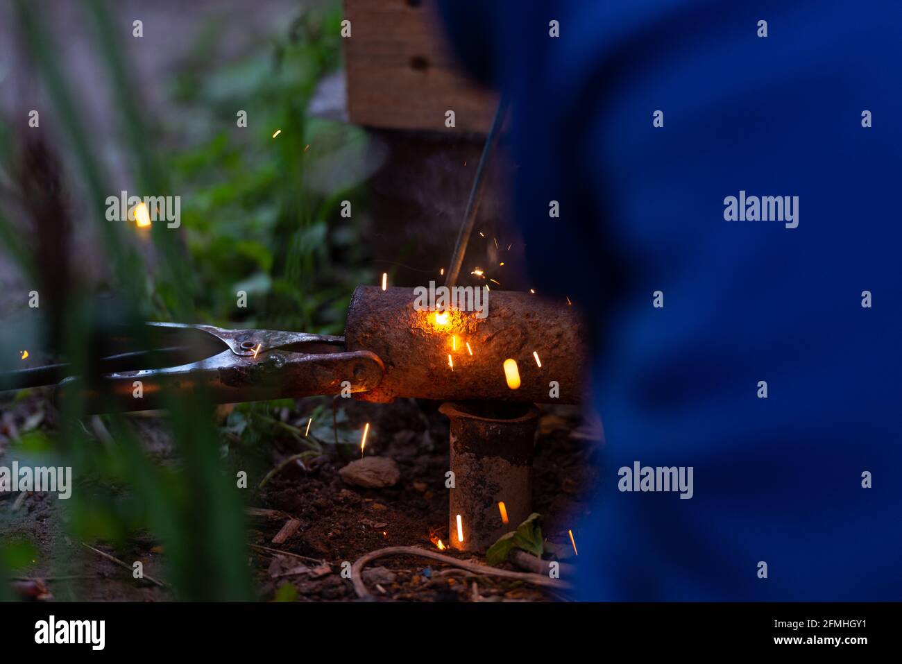 Welding of rusty pipes close-up. From behind the welder's back, we ...