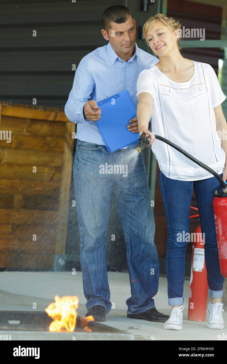 oman demonstrating how to use a fire extinguisher Stock Photo - Alamy