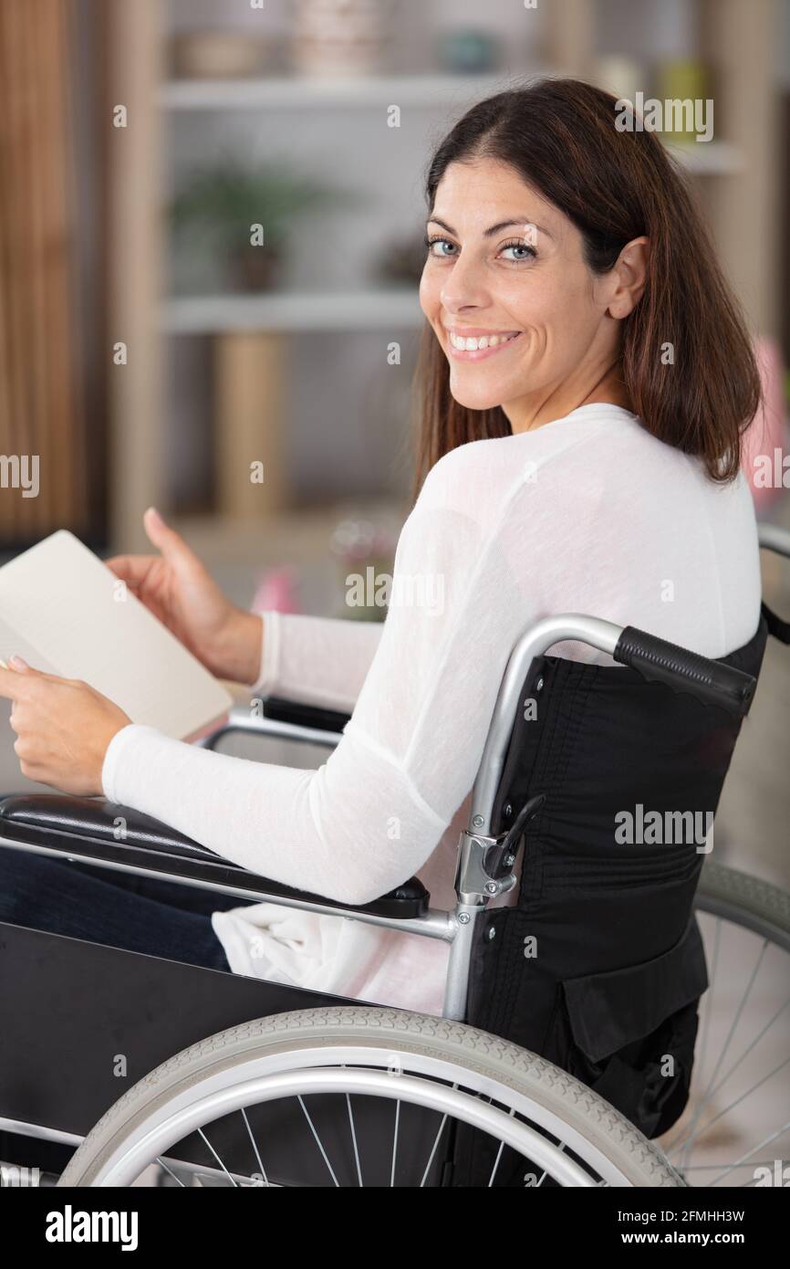 beautiful young disabled woman in wheelchair reading a book Stock Photo ...