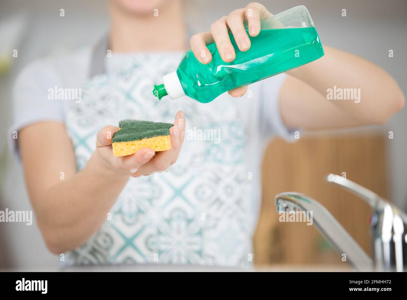 female hand putting washing up liquid on sponge Stock Photo - Alamy