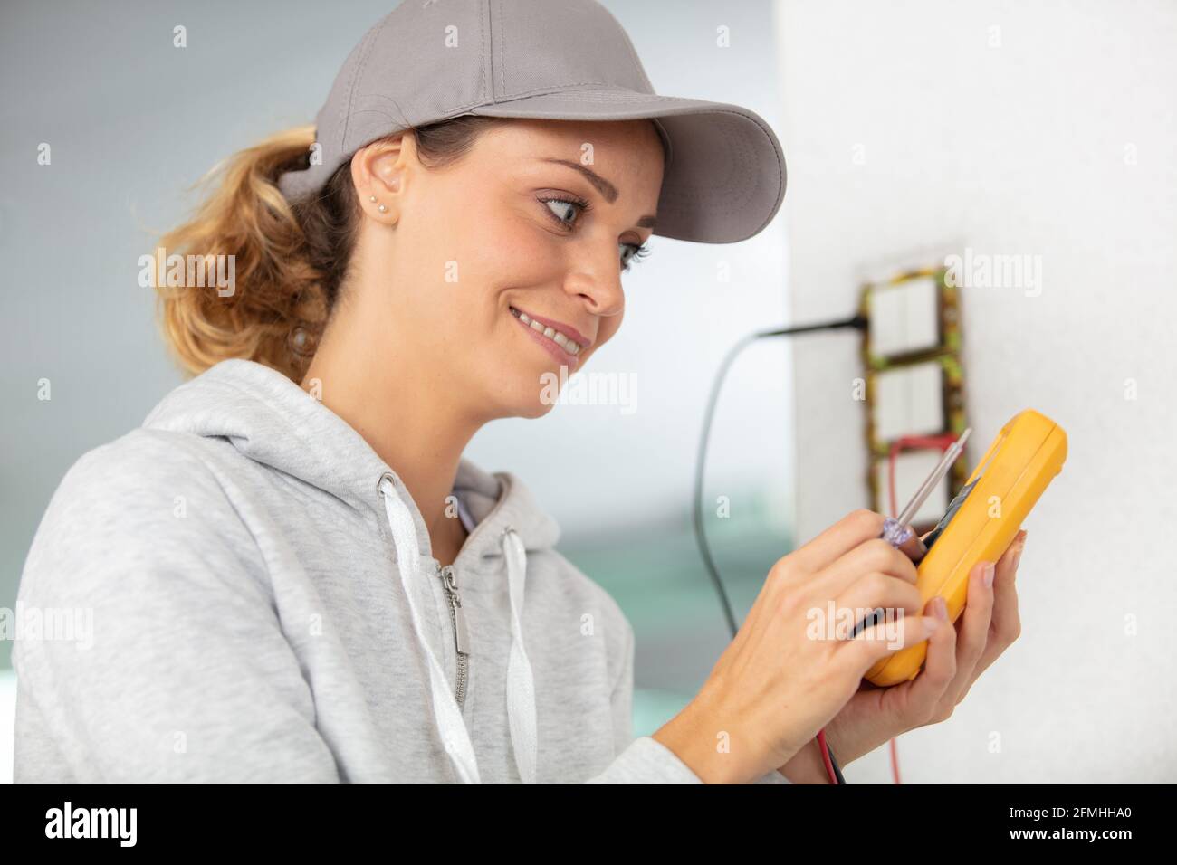 female electrician turns the dial of her multimeter Stock Photo - Alamy