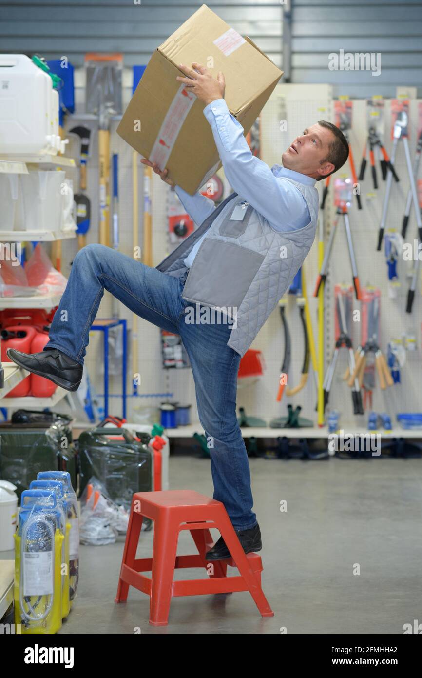 worker carrying a box is going to have an accident Stock Photo - Alamy