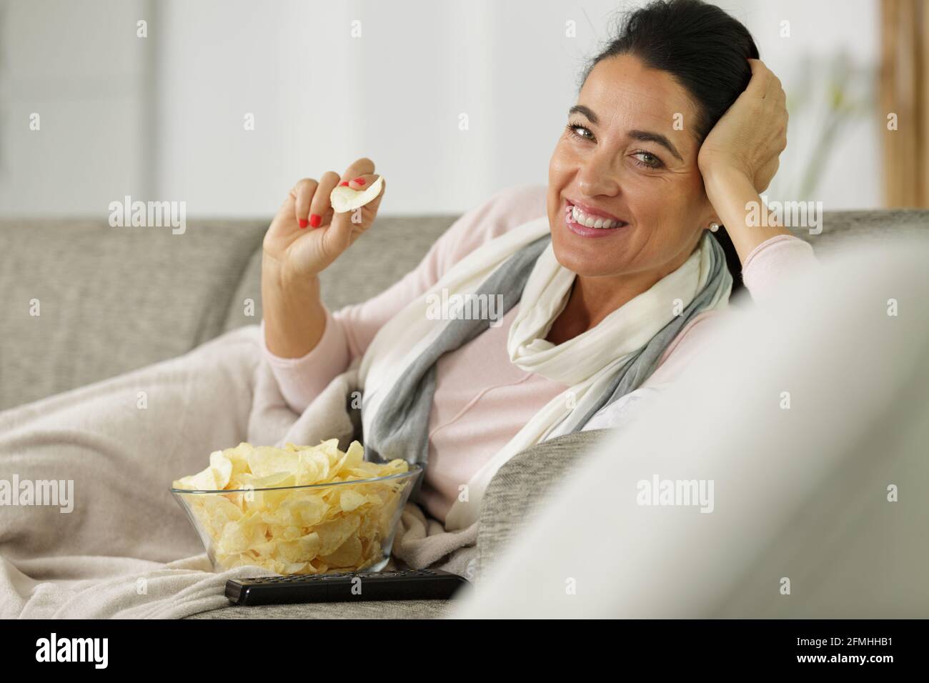 a mature woman eating chips Stock Photo - Alamy