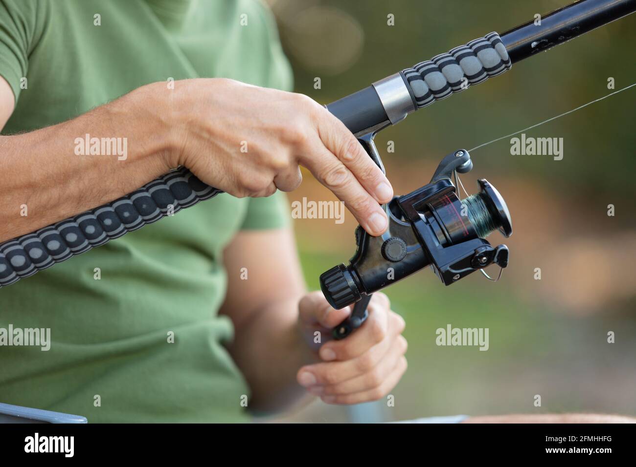 human hand holding fishing rod Stock Photo - Alamy
