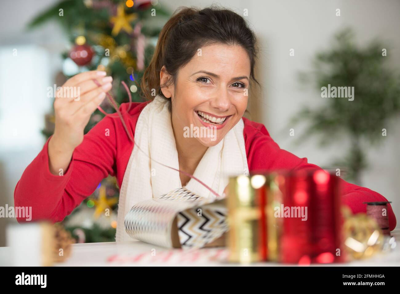 happy woman in red wrapping christmas present Stock Photo - Alamy