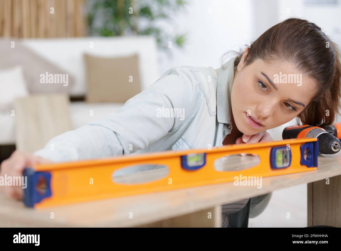 young woman using a spirit level Stock Photo - Alamy