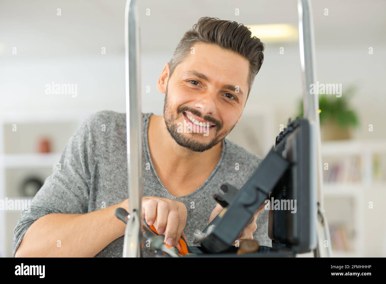man smiling while taking out a tool from the toolbox Stock Photo - Alamy