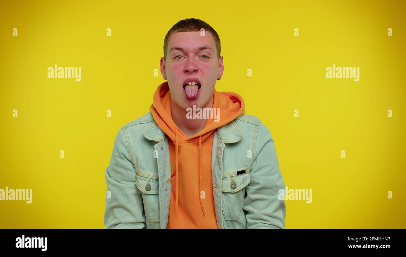 Funny teen man making playful silly facial expressions and grimacing ...