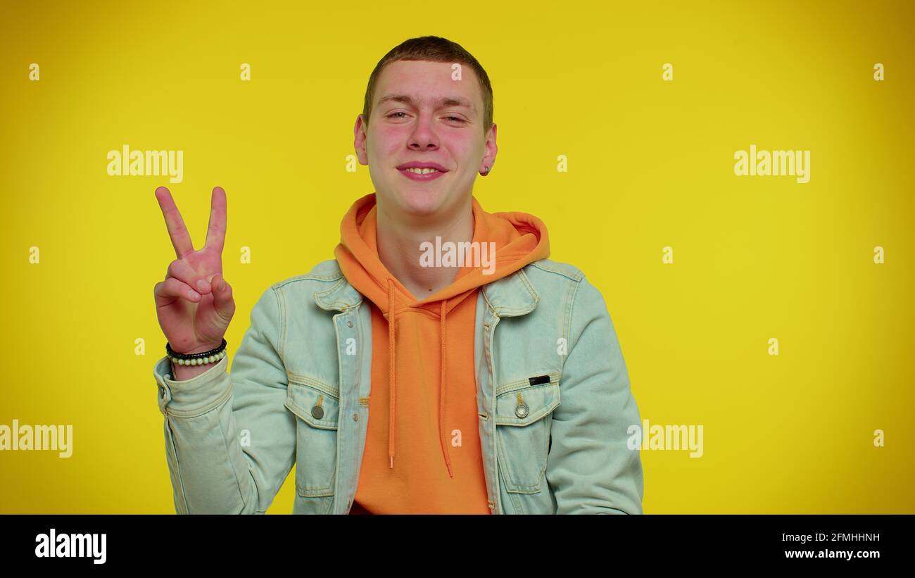 Handsome stylish smiling man showing victory sign, hoping for success ...