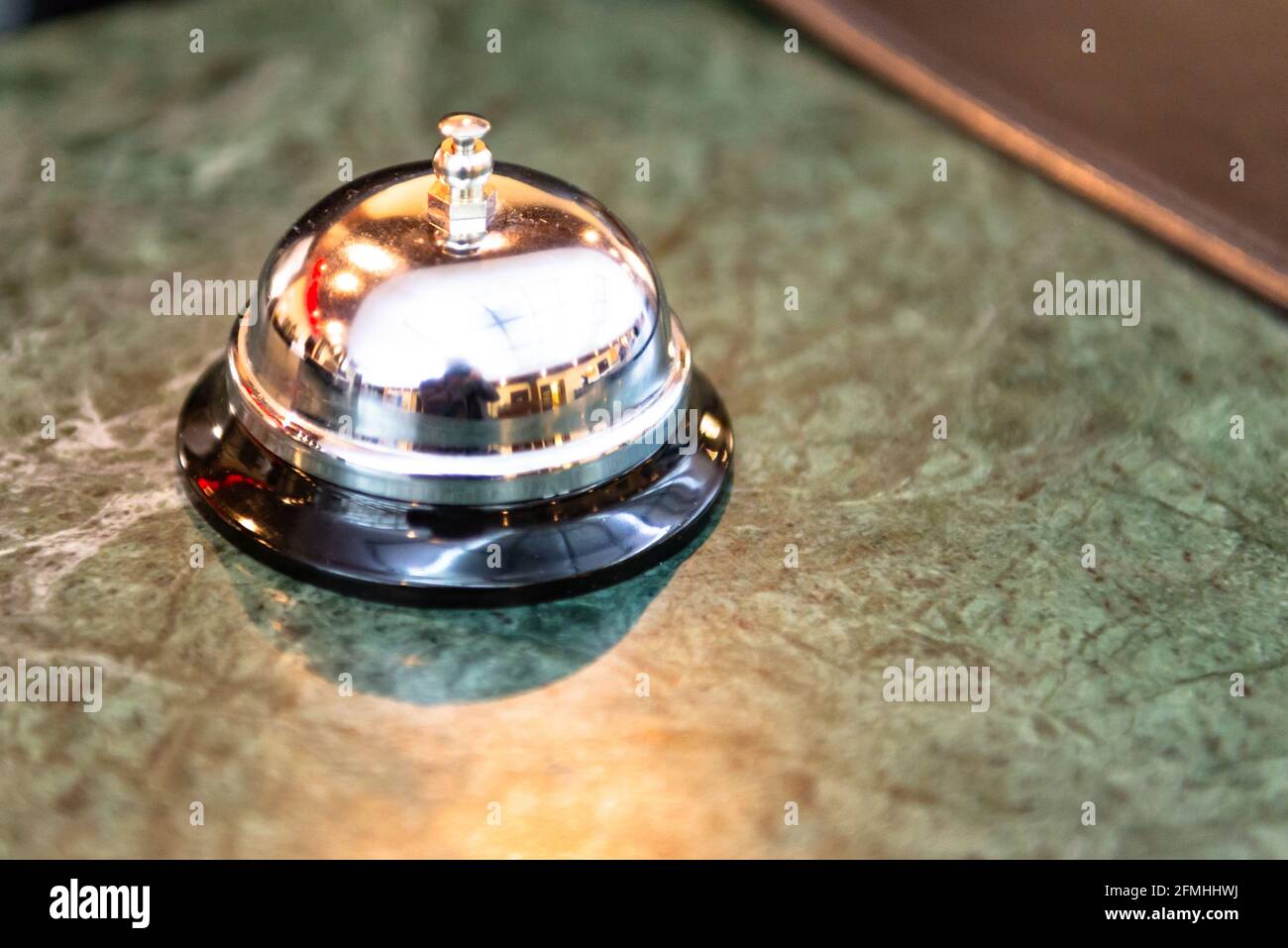 Call to the hotel reception. A shiny mechanical bell on the table ...