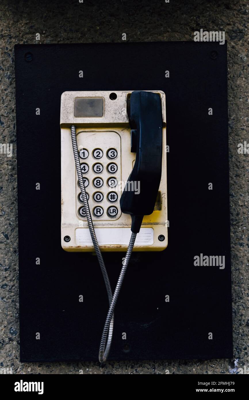 A vertical shot of an old telephone against the wal Stock Photo - Alamy