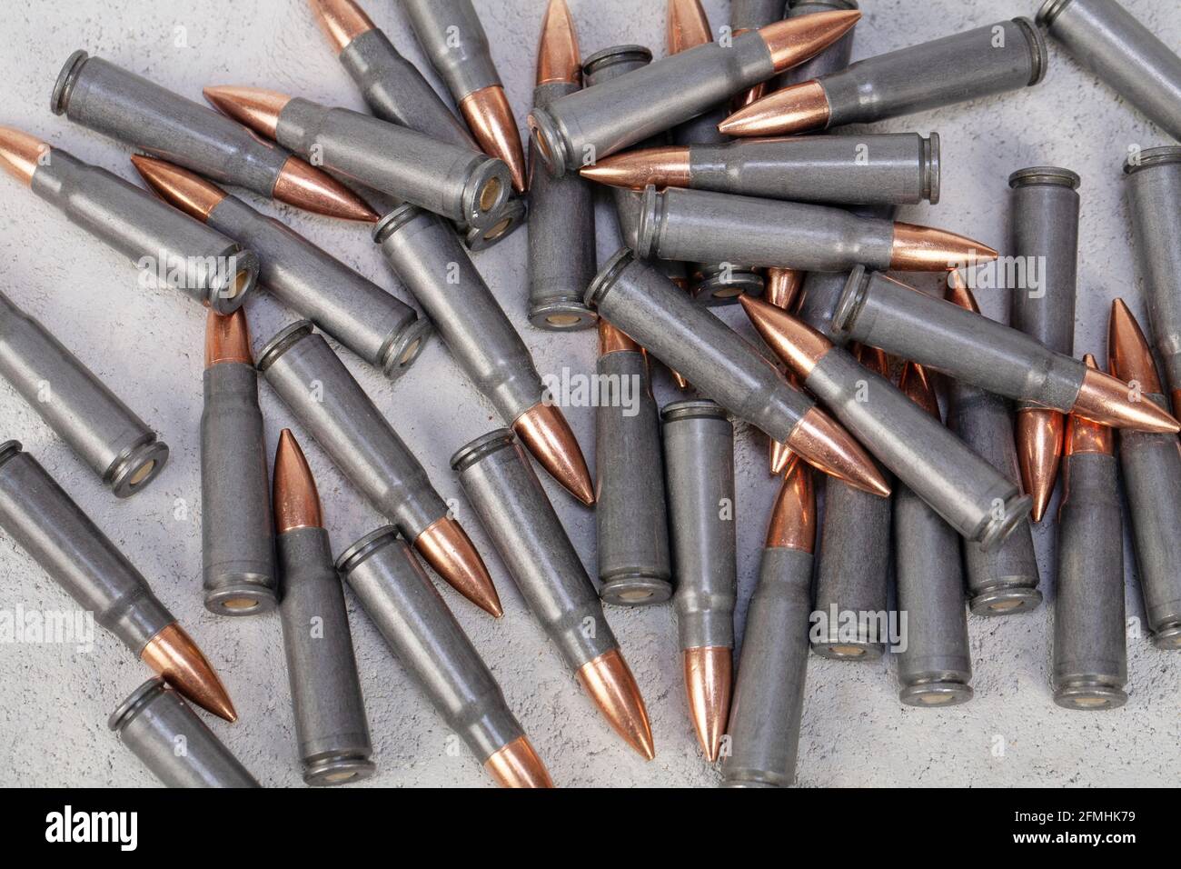 kalashnikov ak gun 7,62 mm bullets on grey concrete surface background ...