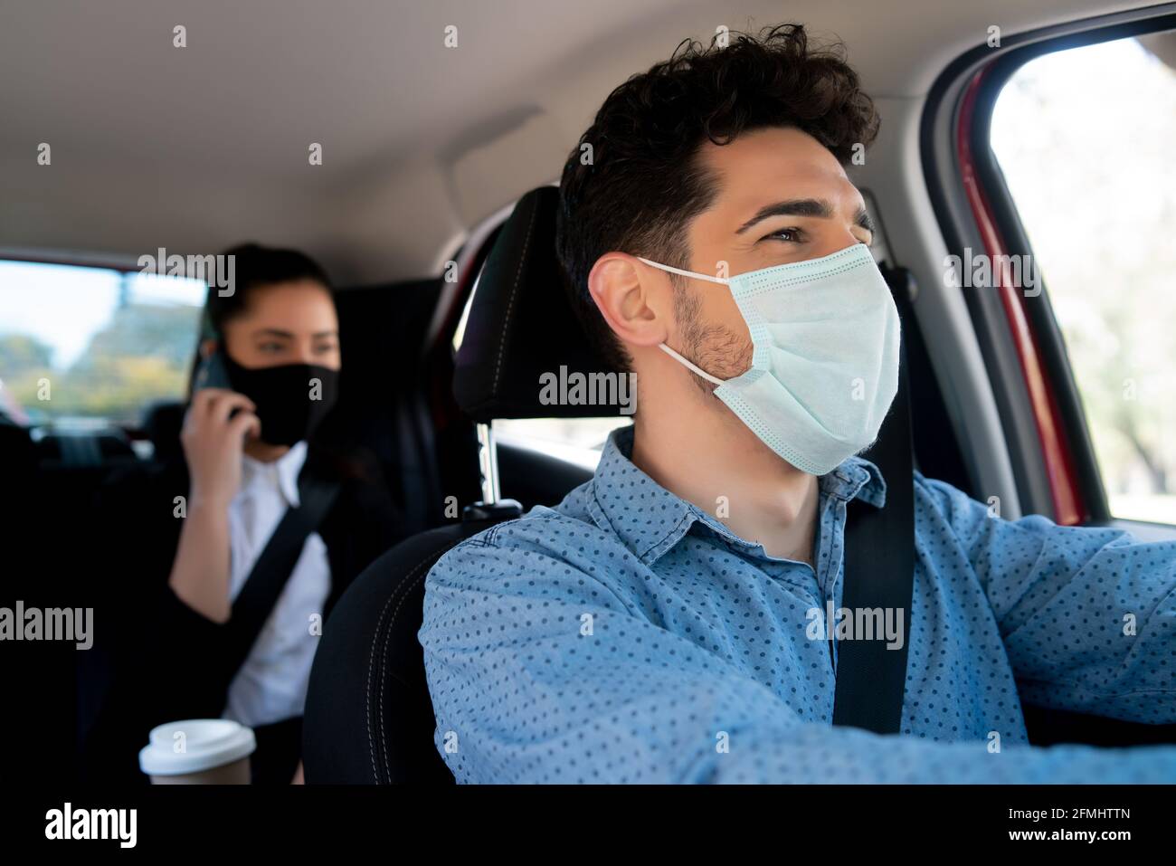 Taxi driver with passenger at back seat Stock Photo - Alamy