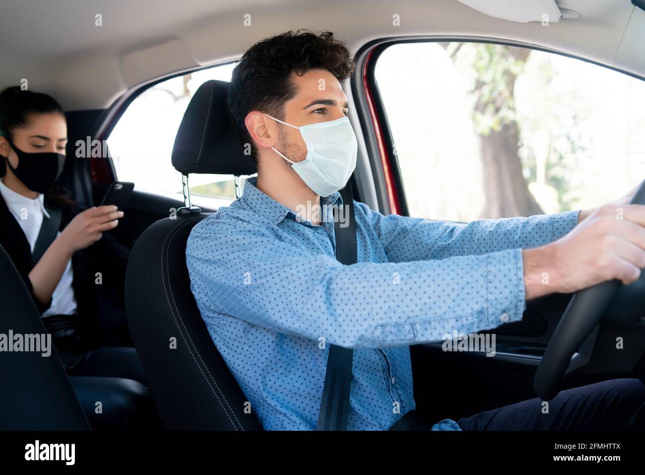 Taxi driver with passenger at back seat Stock Photo - Alamy