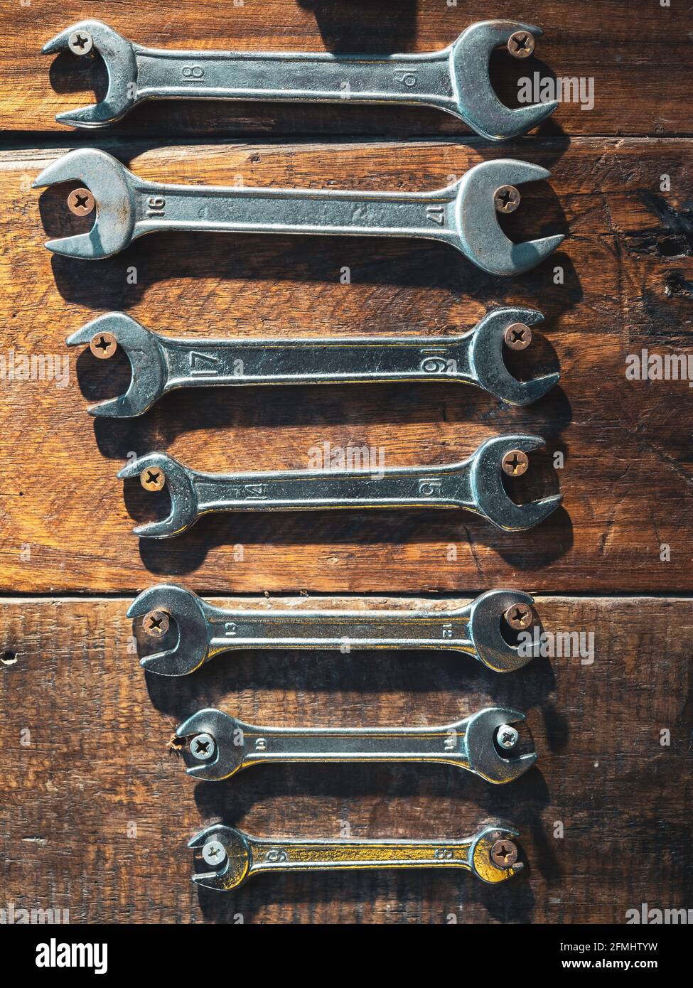 Set of wrench hanging on wooden wall background, vertical style. Many ...